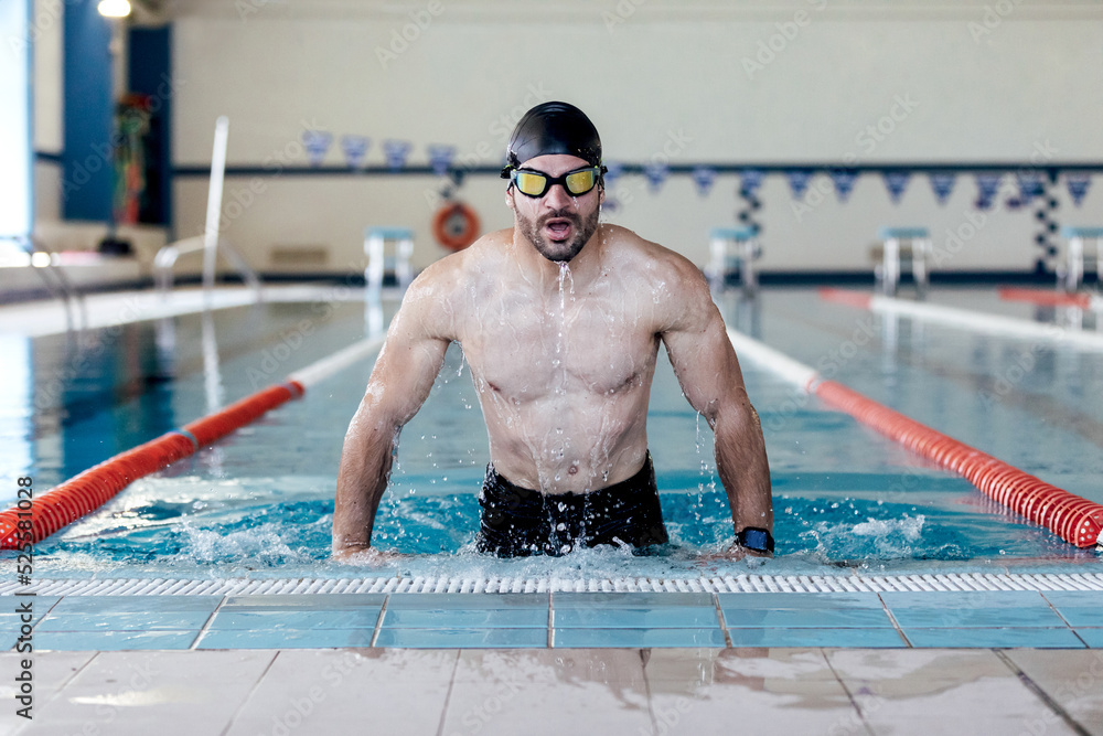 Strong sportsman in swimming goggles in pool with splashing water Stock ...