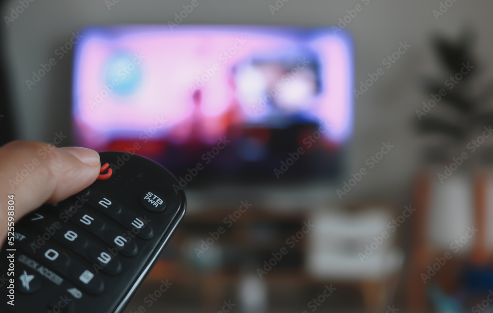 Hand holding remote control of a television. Hands pointing to tv ...