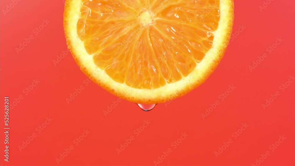 Water drop falling from orange hue orange on red background. Orange ...