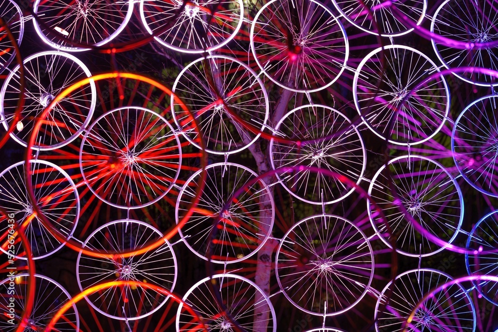 Wall of bicycle wheels in colorful artificial light at night Stock ...