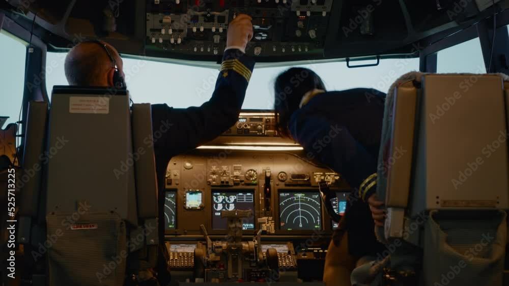 Captain and woman copilot in cockpit preparing to fly airplane, using ...
