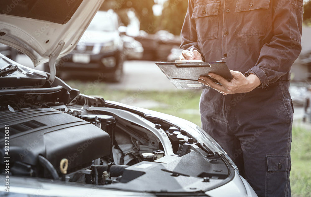 Car mechanical engineering doing checklist to estimate repair quotation ...