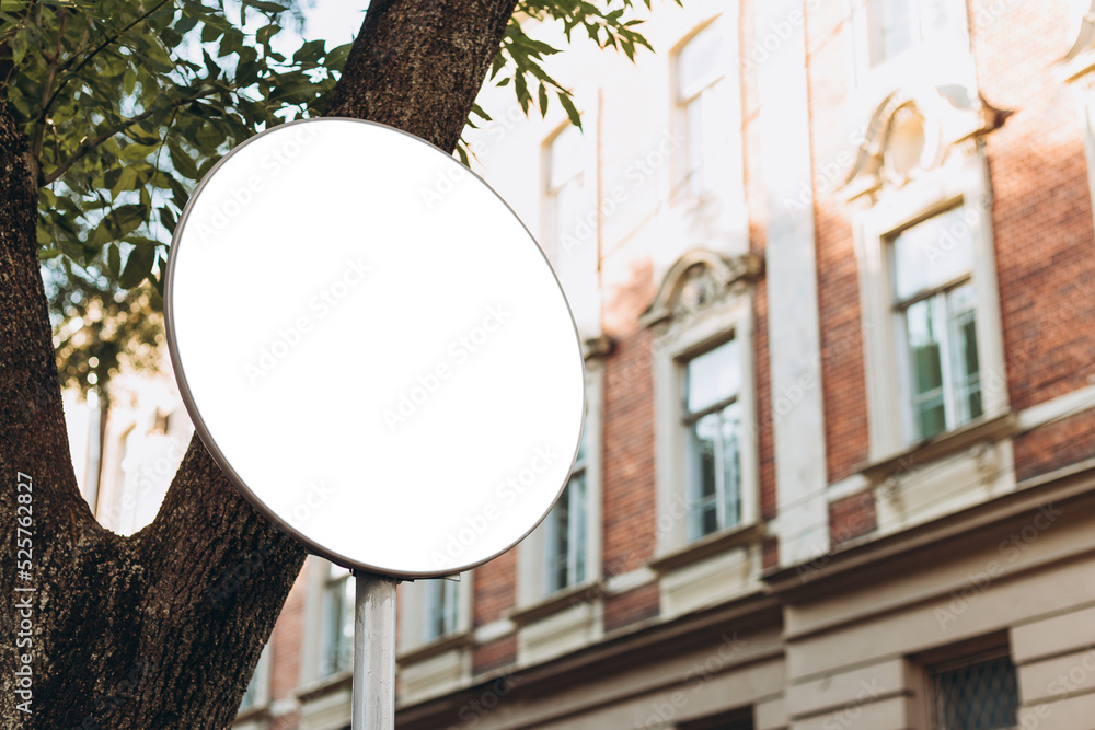 Round sign on the street in the city. Mock-up of a white circle to ...