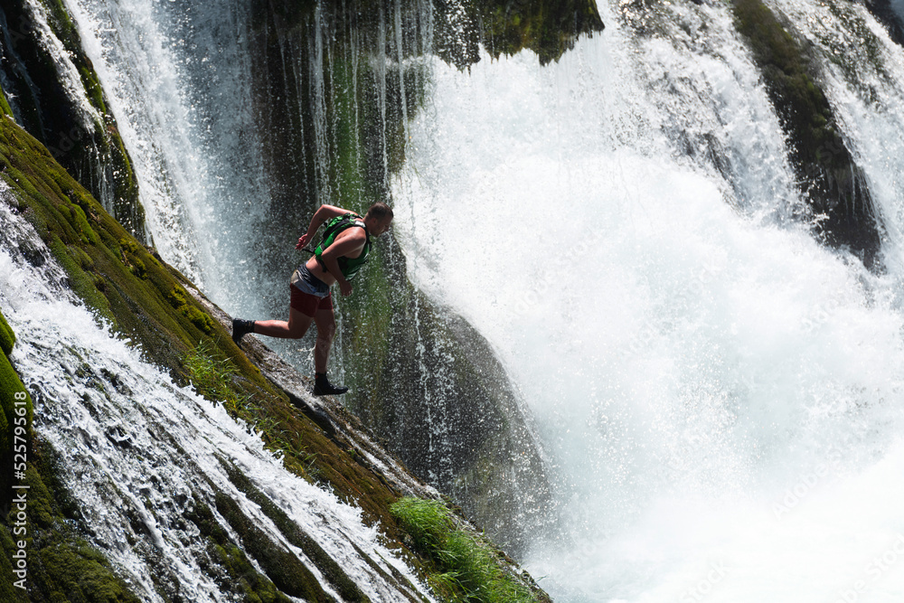 waterfall extreme brave man as superhero running jump and dive from the ...