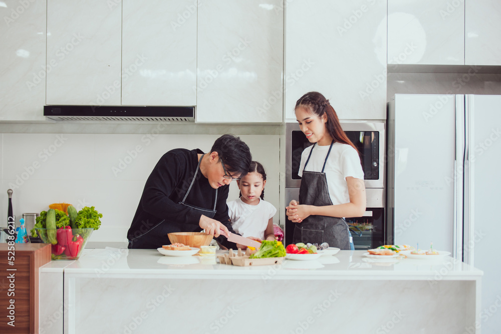 Asian family cooking at home. Happy family cooks together in the ...