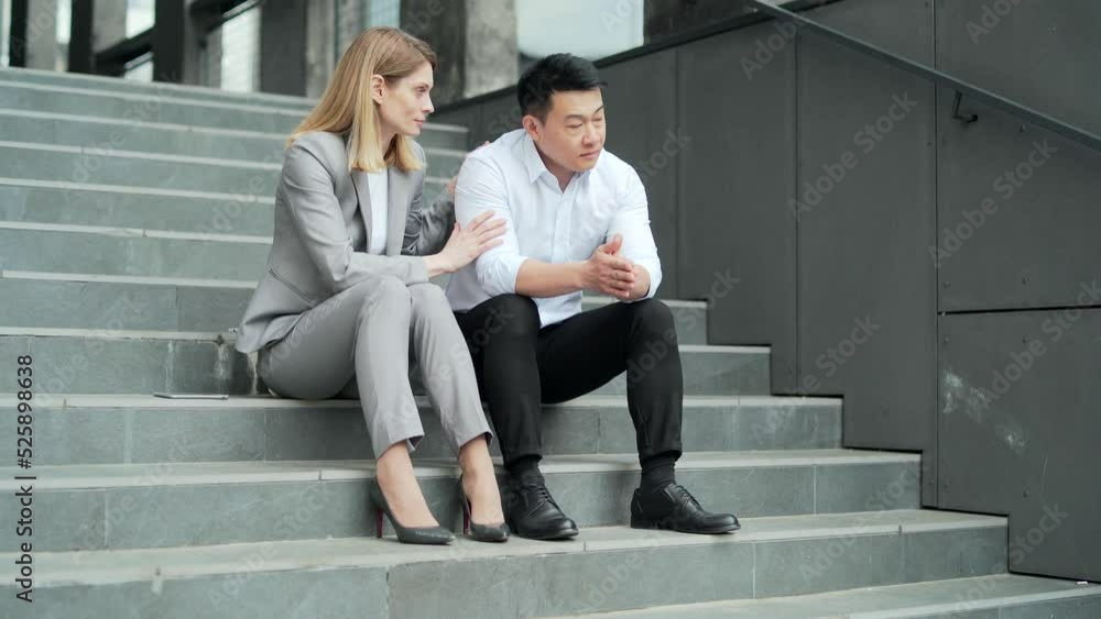 Asian male employee supports upset depressed female co-worker colleague ...