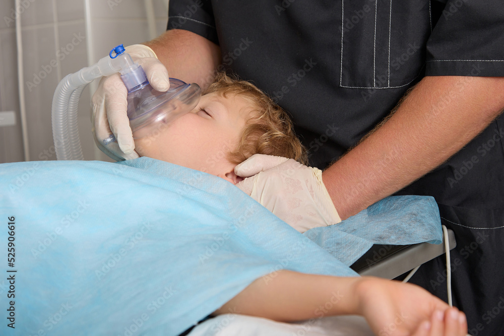 Close-up of a little boy sleeping in the intensive care unit under a ...