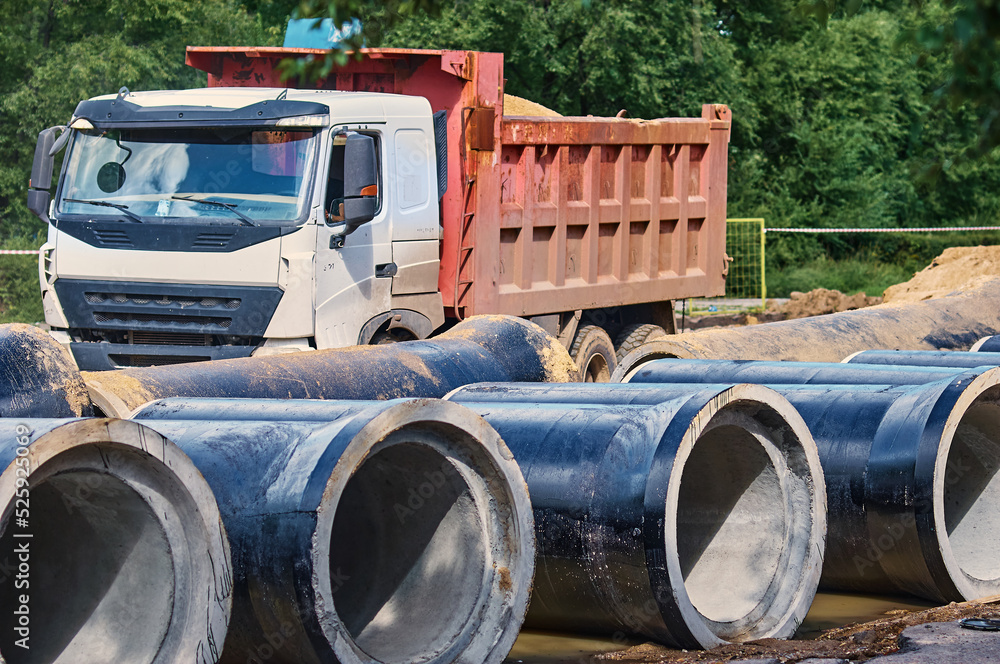 New sewer reinforced concrete pipes lie on the construction site. Big ...