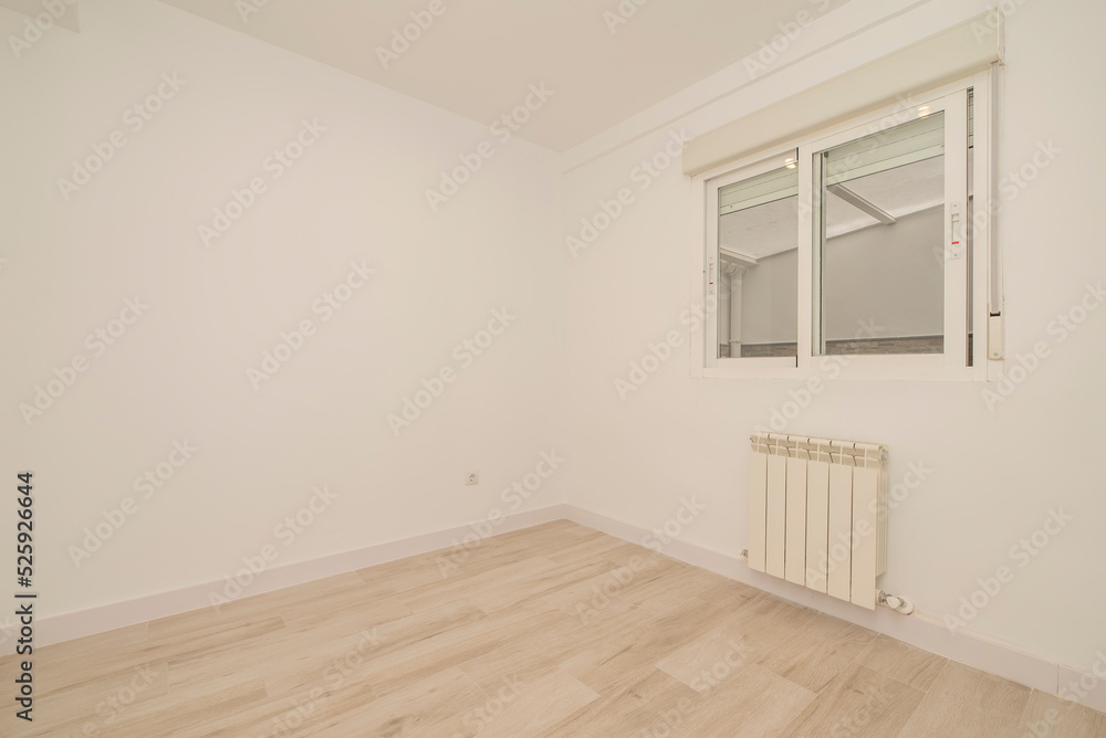 Empty living room with light wooden floorboards, white radiator on the ...