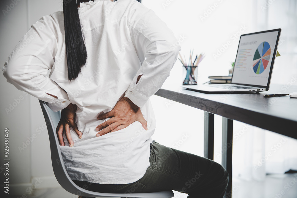 Young asian woman is sitting at work and has tension pain in her neck ...