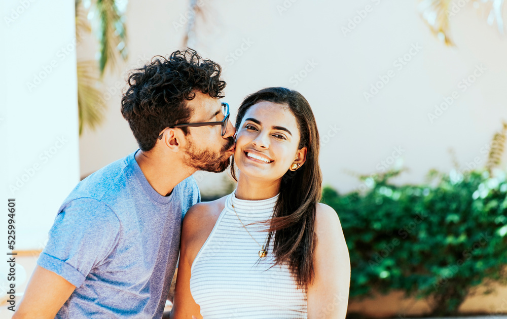 Foto de Boyfriend kissing his girlfriend on the cheek while smiling ...
