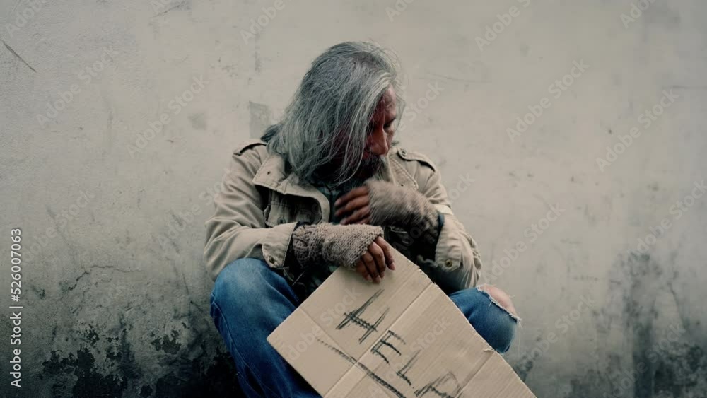 4k, A homeless, long-haired Asian man sits hopelessly leaning against a ...