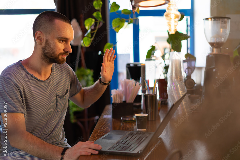 Portrait of male owner of restaurant bar sitting at counter working on ...