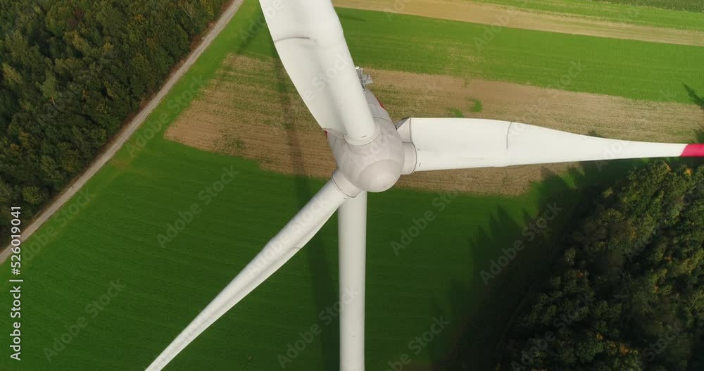Close-up view from copter at the modern white windmill in the golden ...