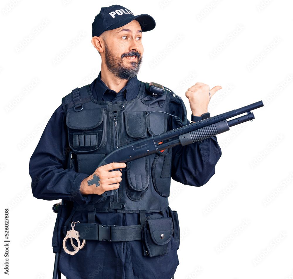 Young handsome man wearing police uniform holding shotgun pointing ...