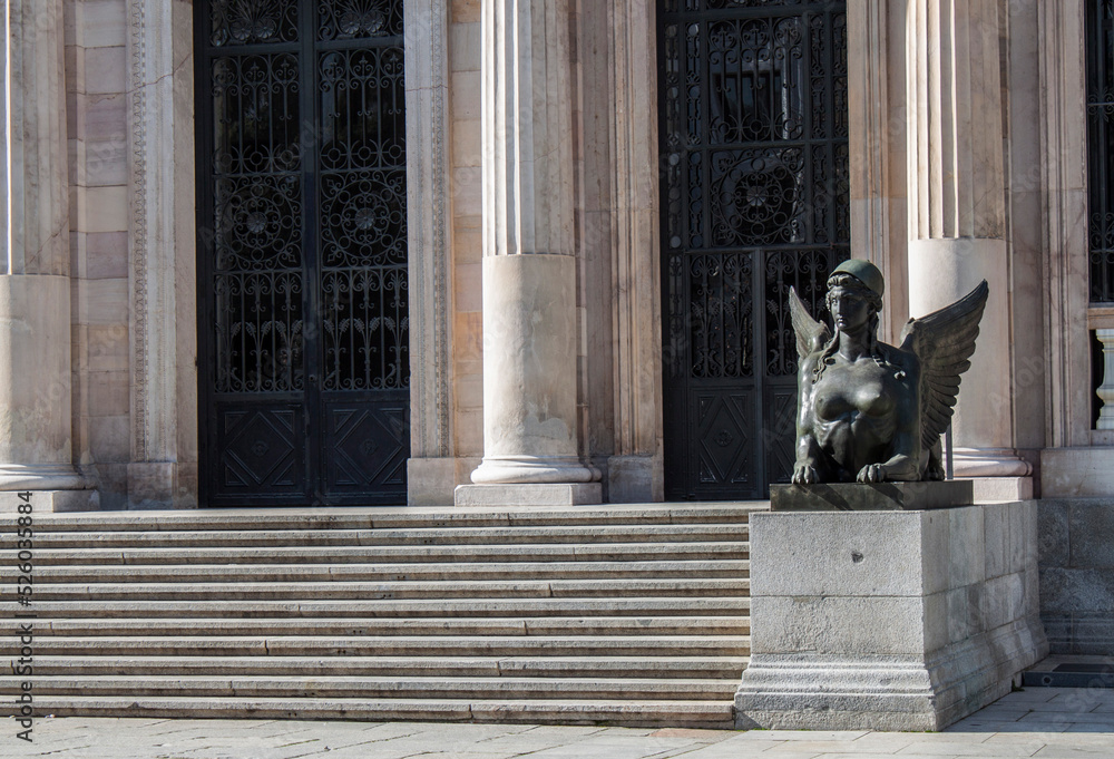 Columns, empty stairs, ancient bronze Siren Sphinx statue. Exterior ...