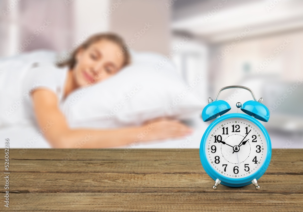 Classic alarm clock on bedside table in bedroom, with happy peaceful ...