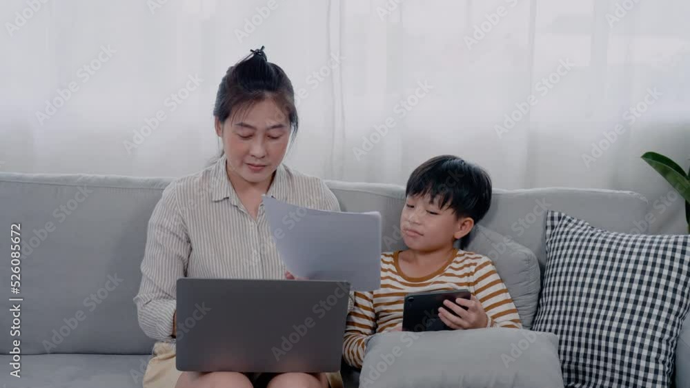 4K, Asian boy, And his mother is working on a laptop computer, The ...