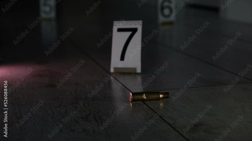 Crime scene, spent shell casings numbered on the floor with a marker ...