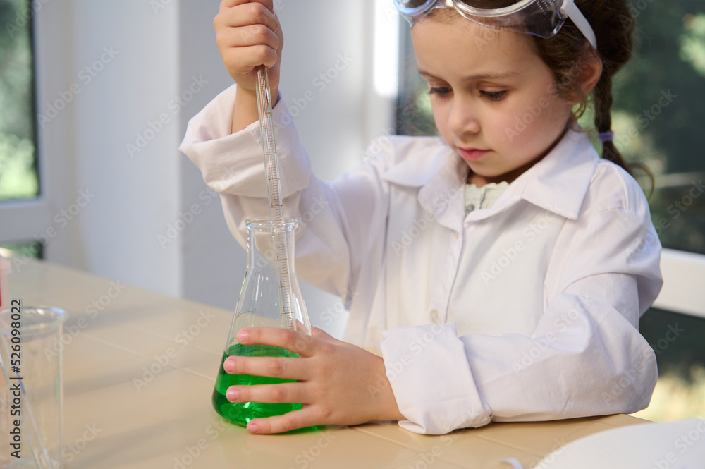 Adorable preschooler girl wearing white lab coat, enjoying learns ...