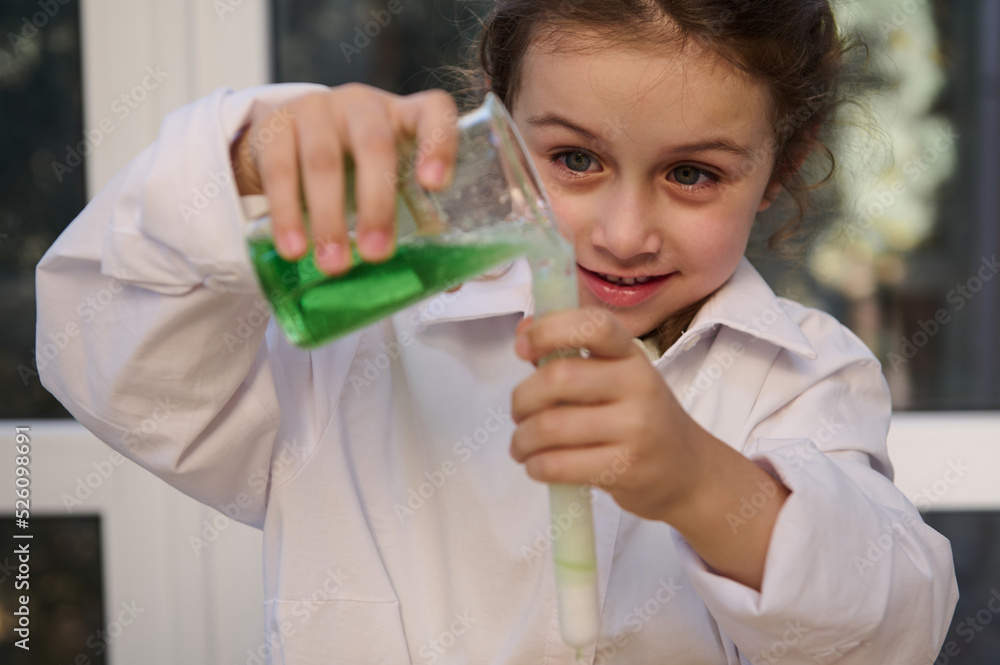 Homeschooling Caucasian little girl in white lab coat learning about ...