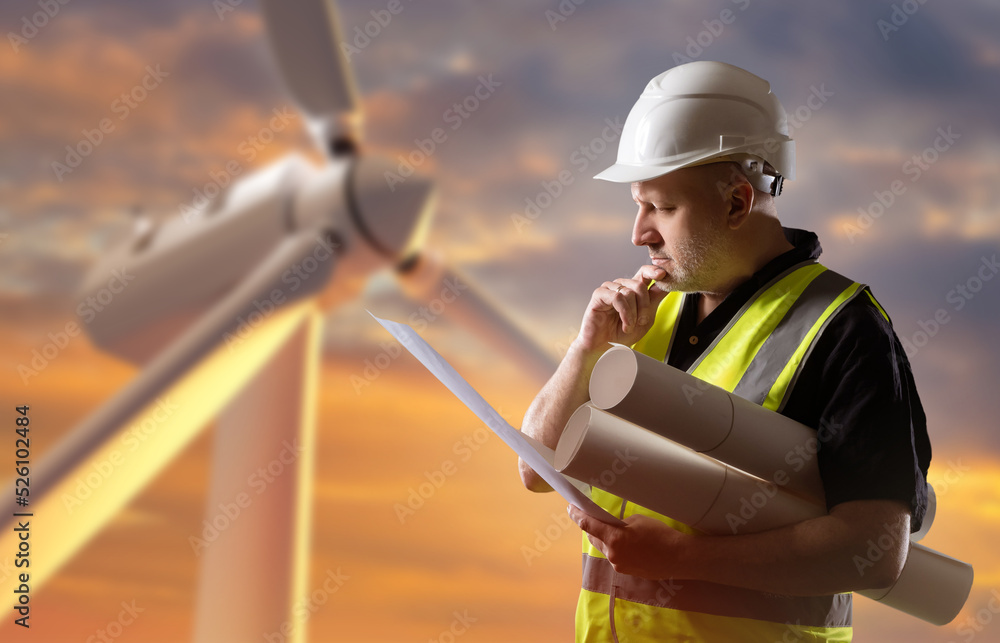 Wind farm builder. Man with construction drawings. Windmill behind man ...
