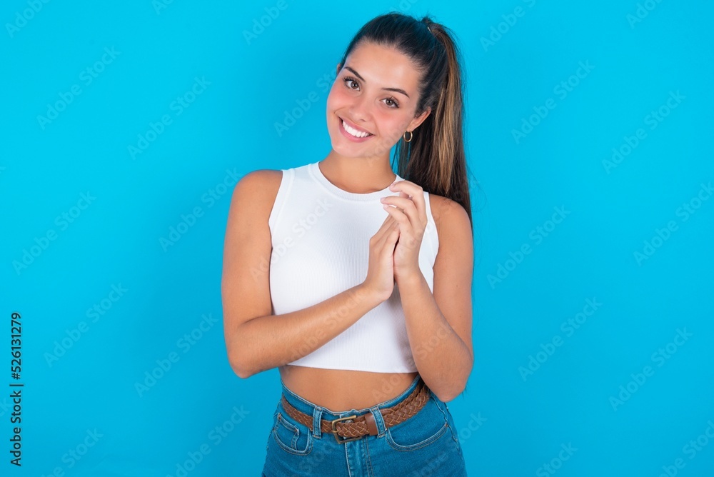 Beautiful Brunette Woman Wearing White Tank Top Over Blue Background