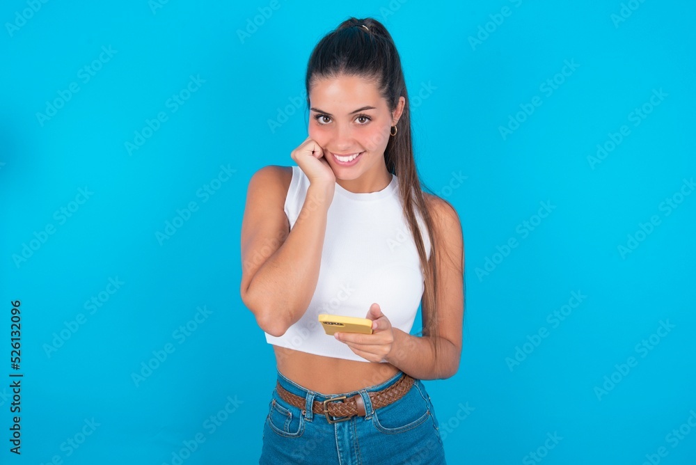 Joyous Beautiful Brunette Woman Wearing White Tank Top Poses With