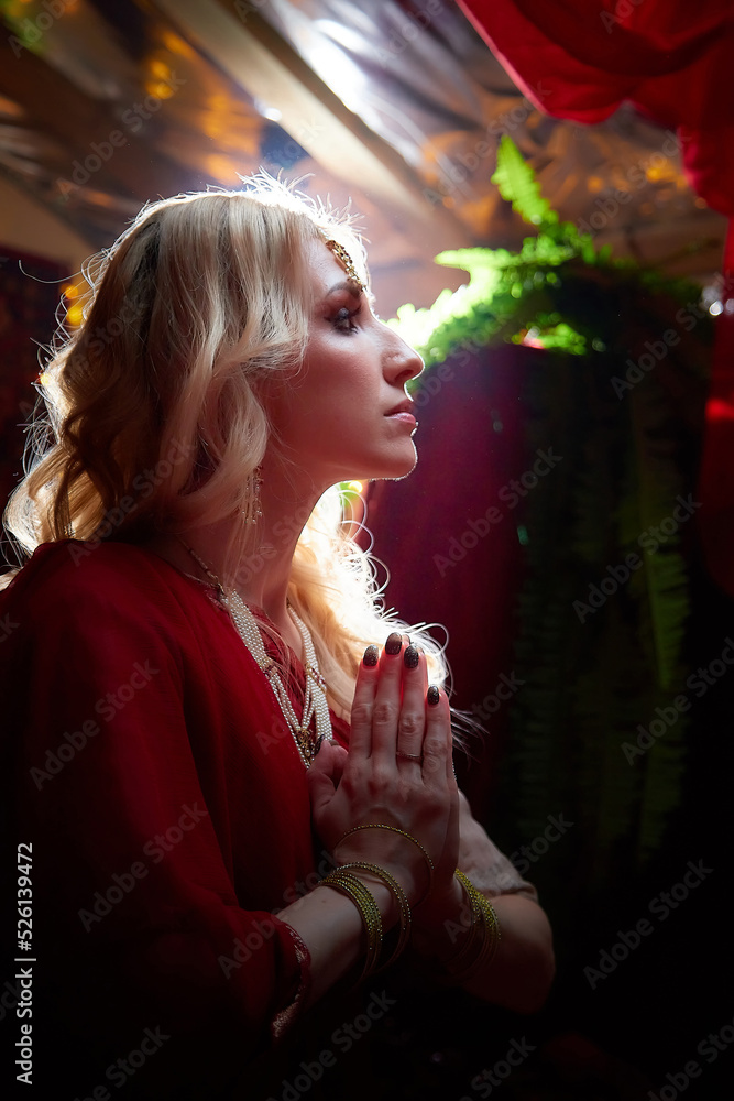 A beautiful European girl looking like an Arab woman in a red room in a ...