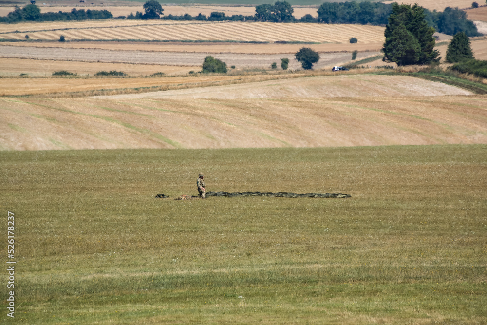 British army paratrooper packing his chute and preparing to move out ...