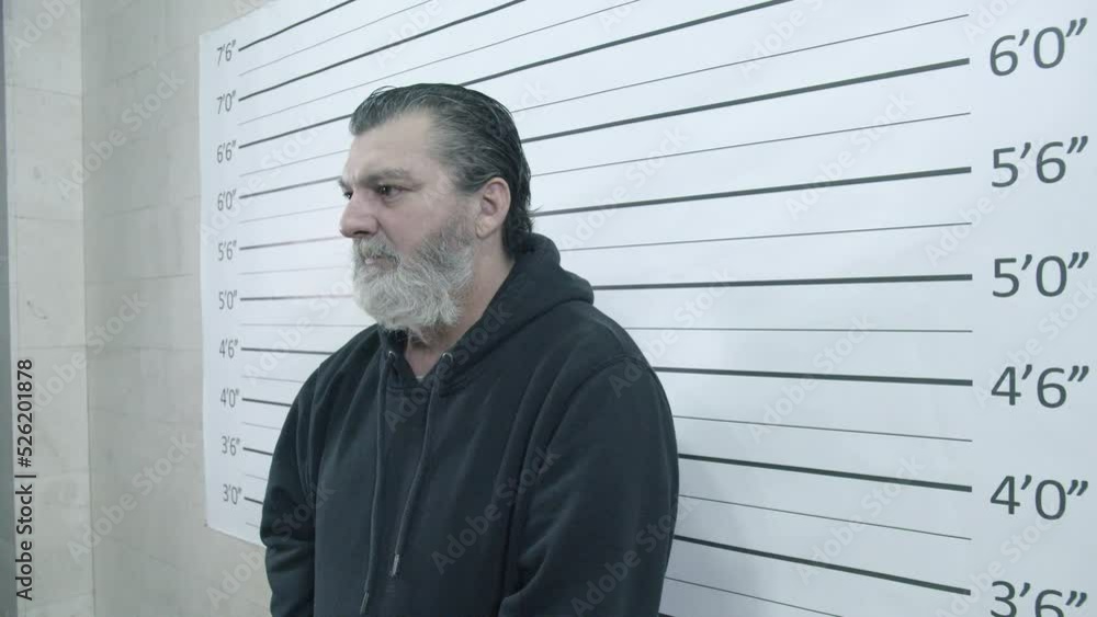Portrait of the arrested male caucasian mature prisoner during mug shot ...