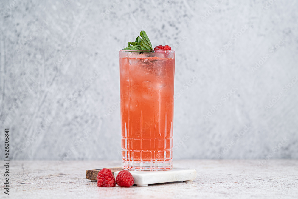 Bebida de frutos rojos con hielo y romero sobre fondo claro de textura ...