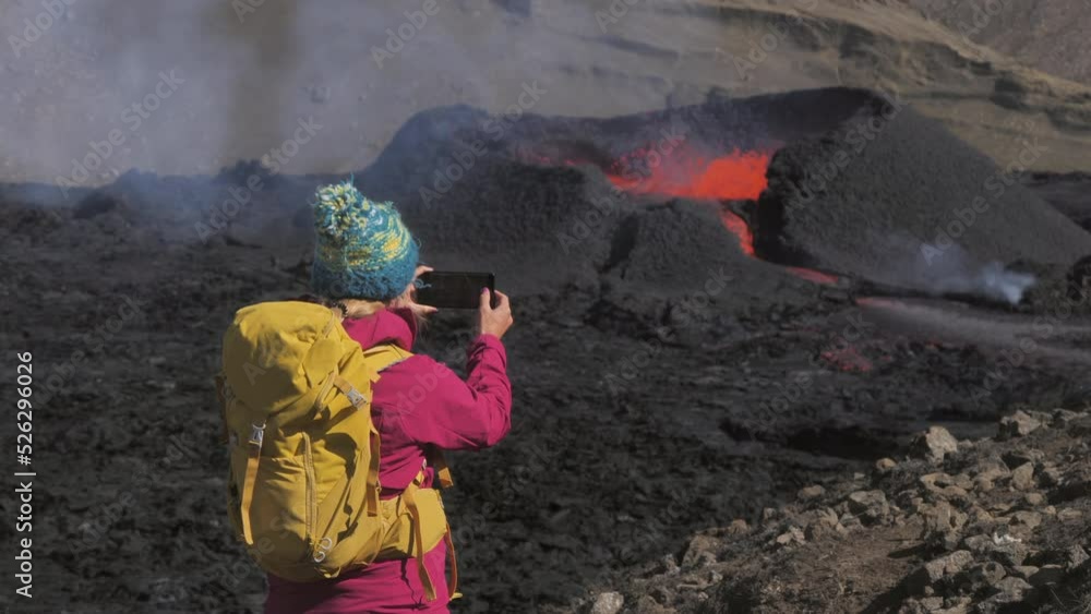 female hiker traveller on top of mountain photographing volcano ...