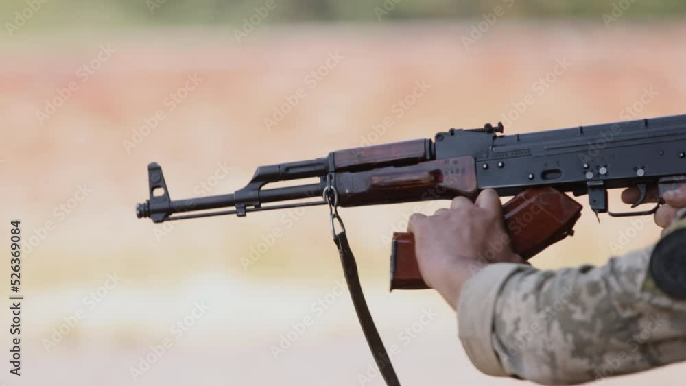 Armed military man unloading machine gun while lying with gun, soldier ...