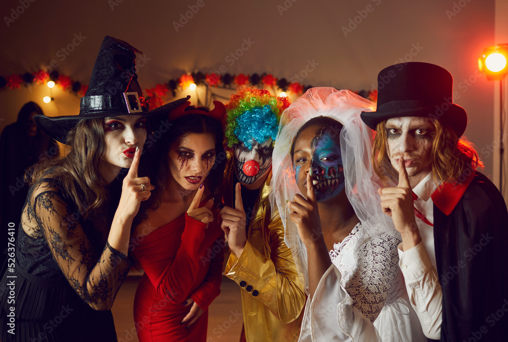 Team of monsters, devils, vampires and witches holding fingers on lips ...