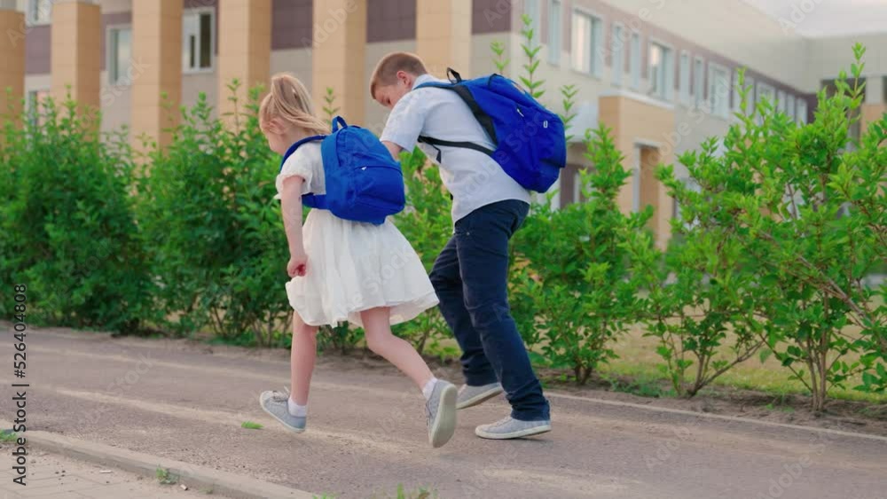 Active students run to school for lesson along sidewalk on city street ...
