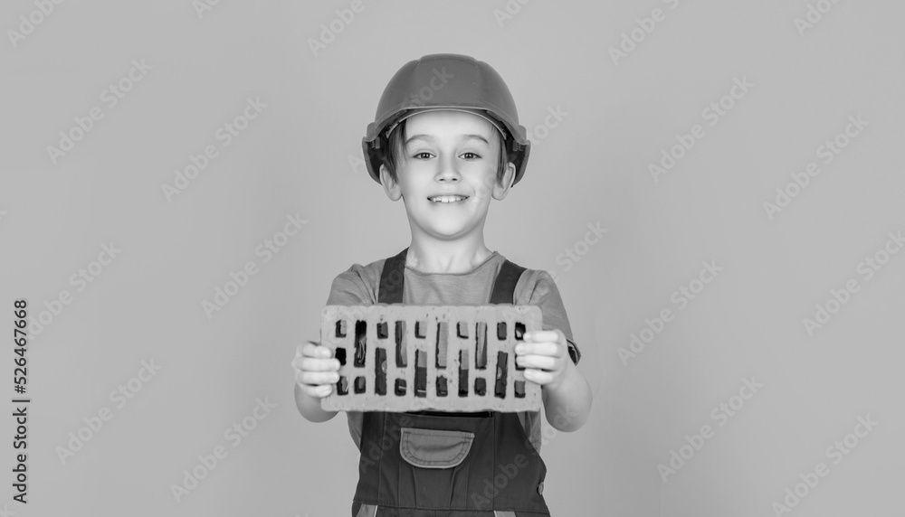 Little builder in helmet. Child dressed as a workman builder. Boy in a ...