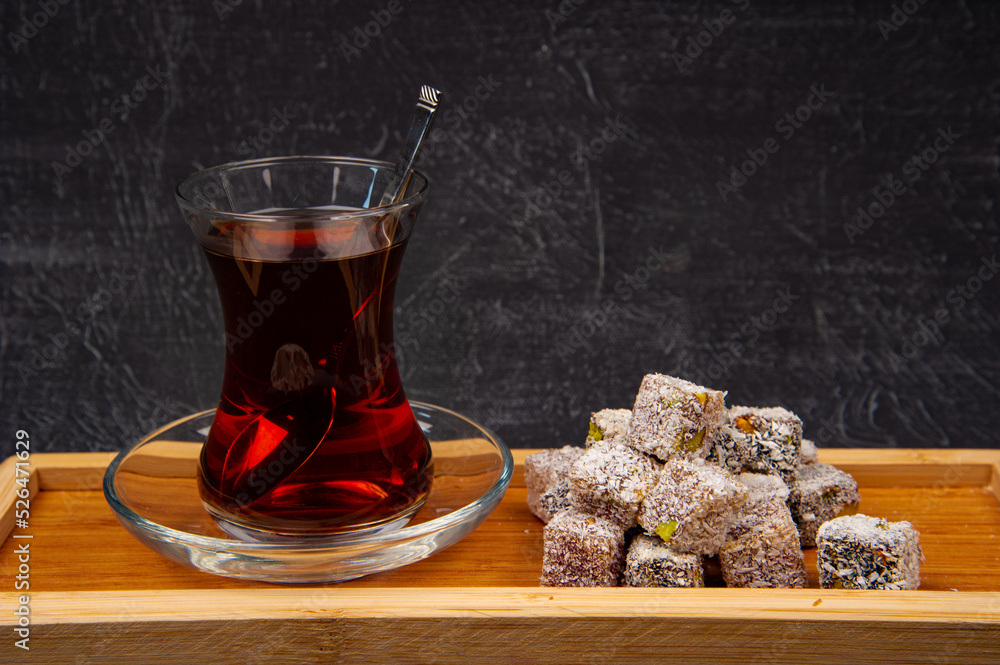 Turkish Delight and Turkish tea in wooden plate on black background ...