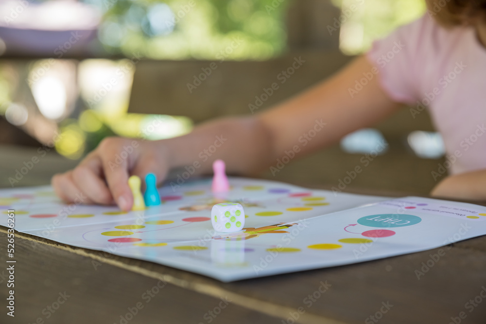 Board game and kids leisure concept - little girl hold figure in hand ...