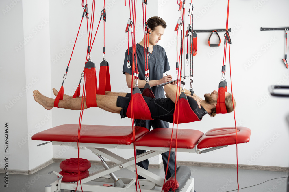 Rehabilitation specialist examining male patient before active ...