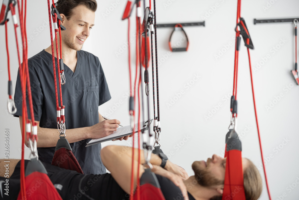 Rehabilitation specialist examining male patient before active ...