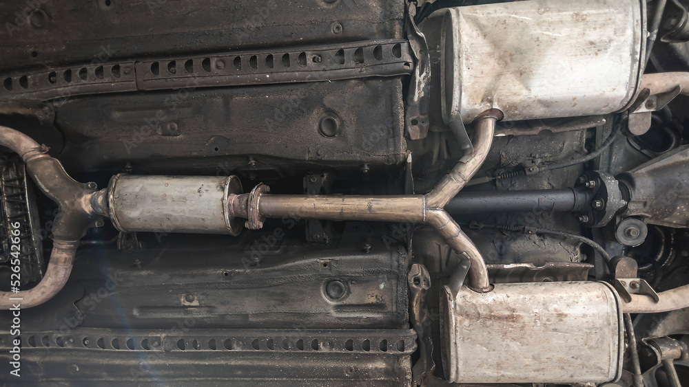 A dual exhaust muffler system installed underneath the chassis of a ...