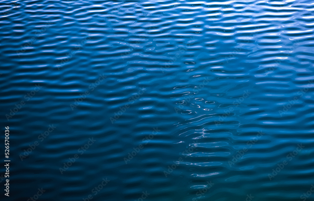 Smooth water blue. water background and sun reflections. textured ...