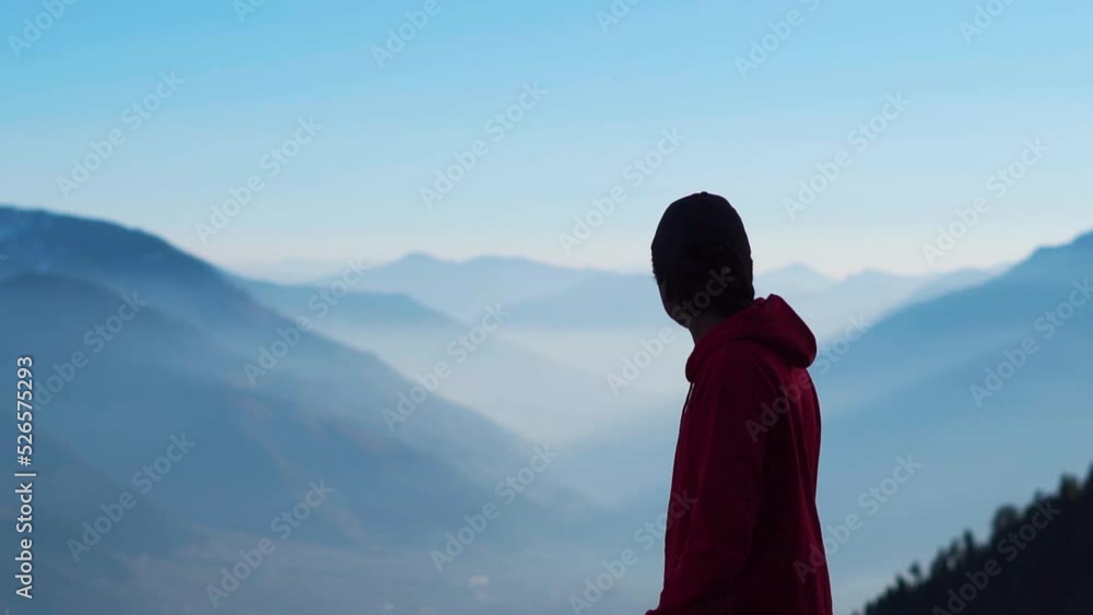 Silhouette shot of an Indian man wearing cap staring at the foggy ...