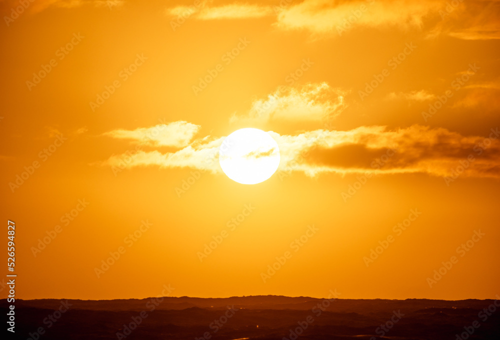 paisaje de ocaso en la playa con silueta del sol sobre el mar con olas ...