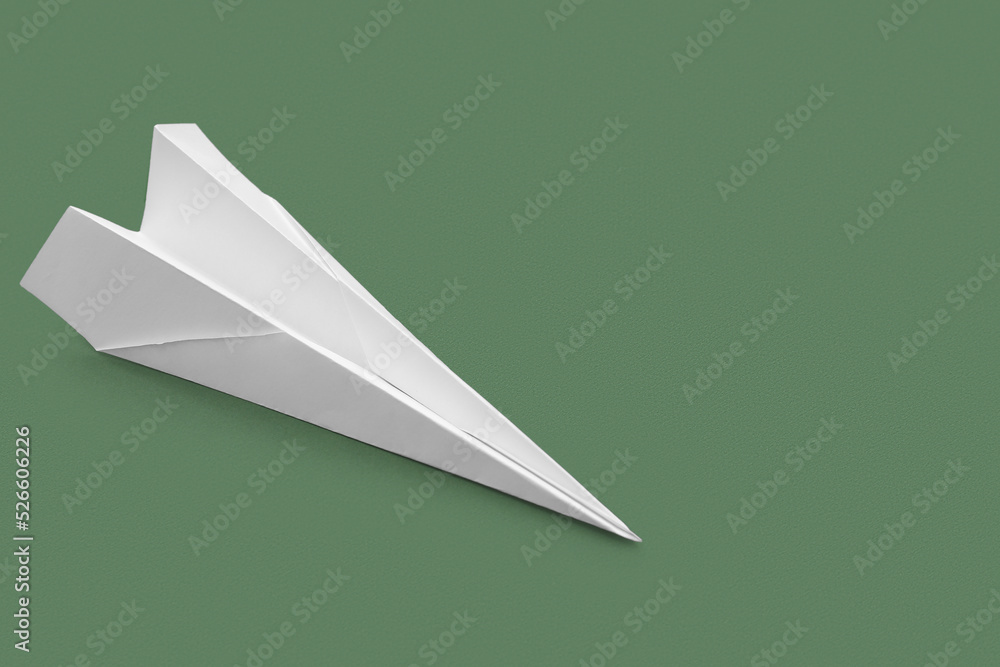 White paper plane on green background Stock Photo | Adobe Stock