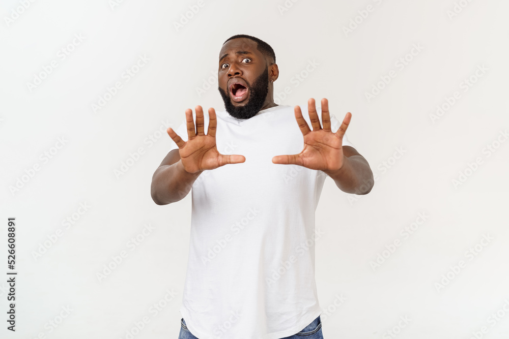 Portrait of shocked young African American man wearing white blank T ...