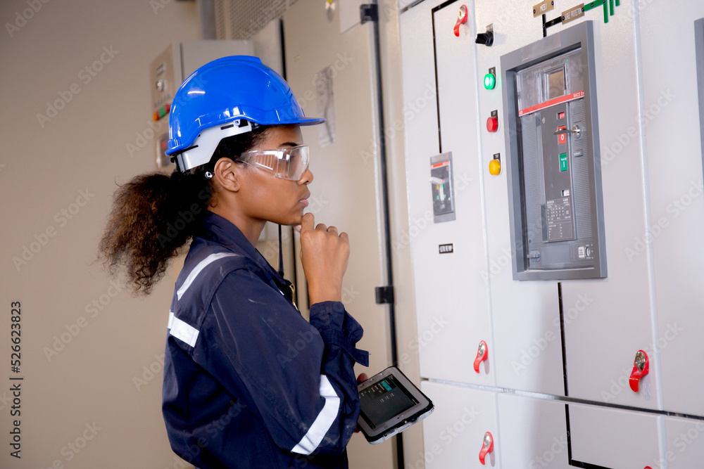 Electrical young asian woman engineer examining maintenance cabinet ...