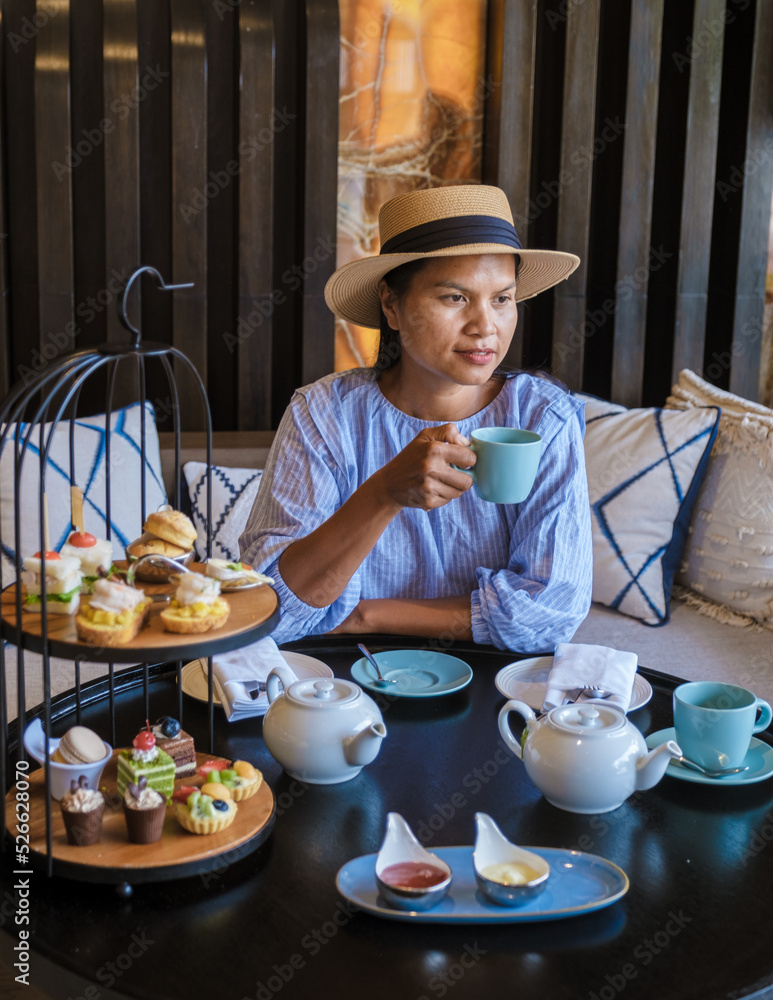 Asian women having a Luxury high tea with snacks and tea in a luxury ...