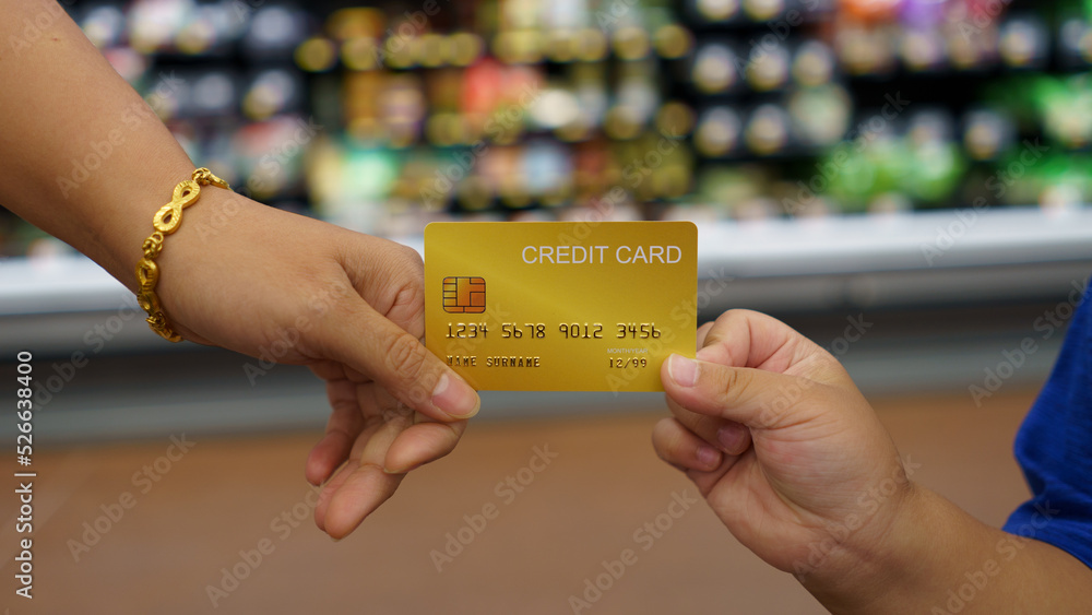 hand holding credit card blur supermarket store background. Woman at ...